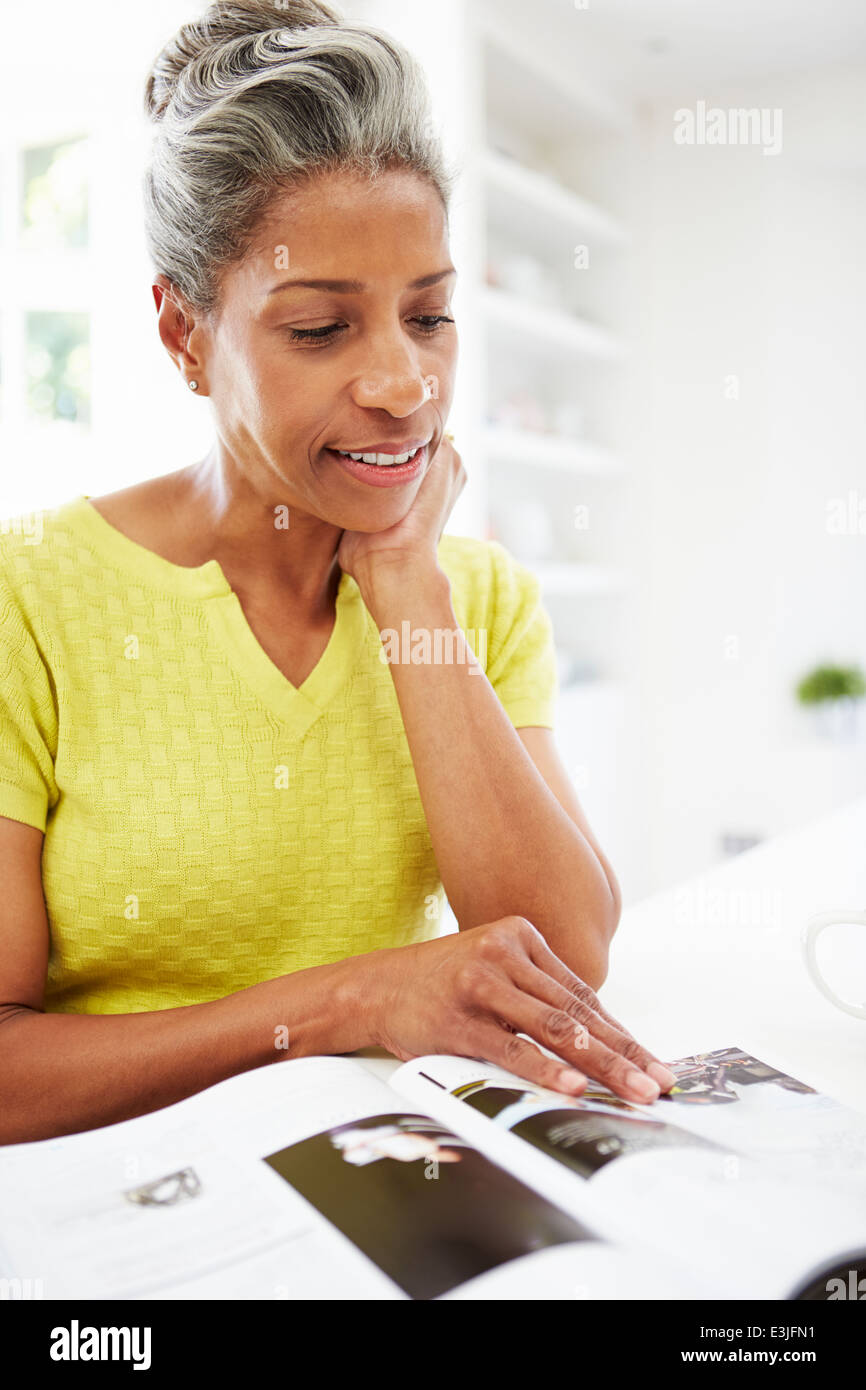 Woman Eating Breakfast And Reading Magazine Stock Photo - Alamy