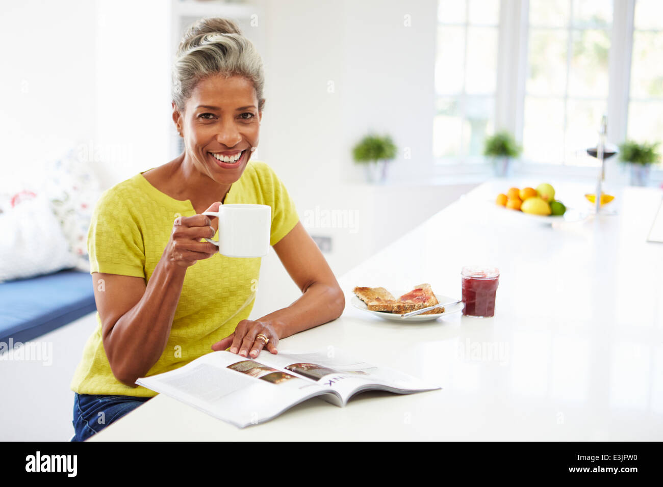 Woman Eating Breakfast And Reading Magazine Stock Photo - Alamy