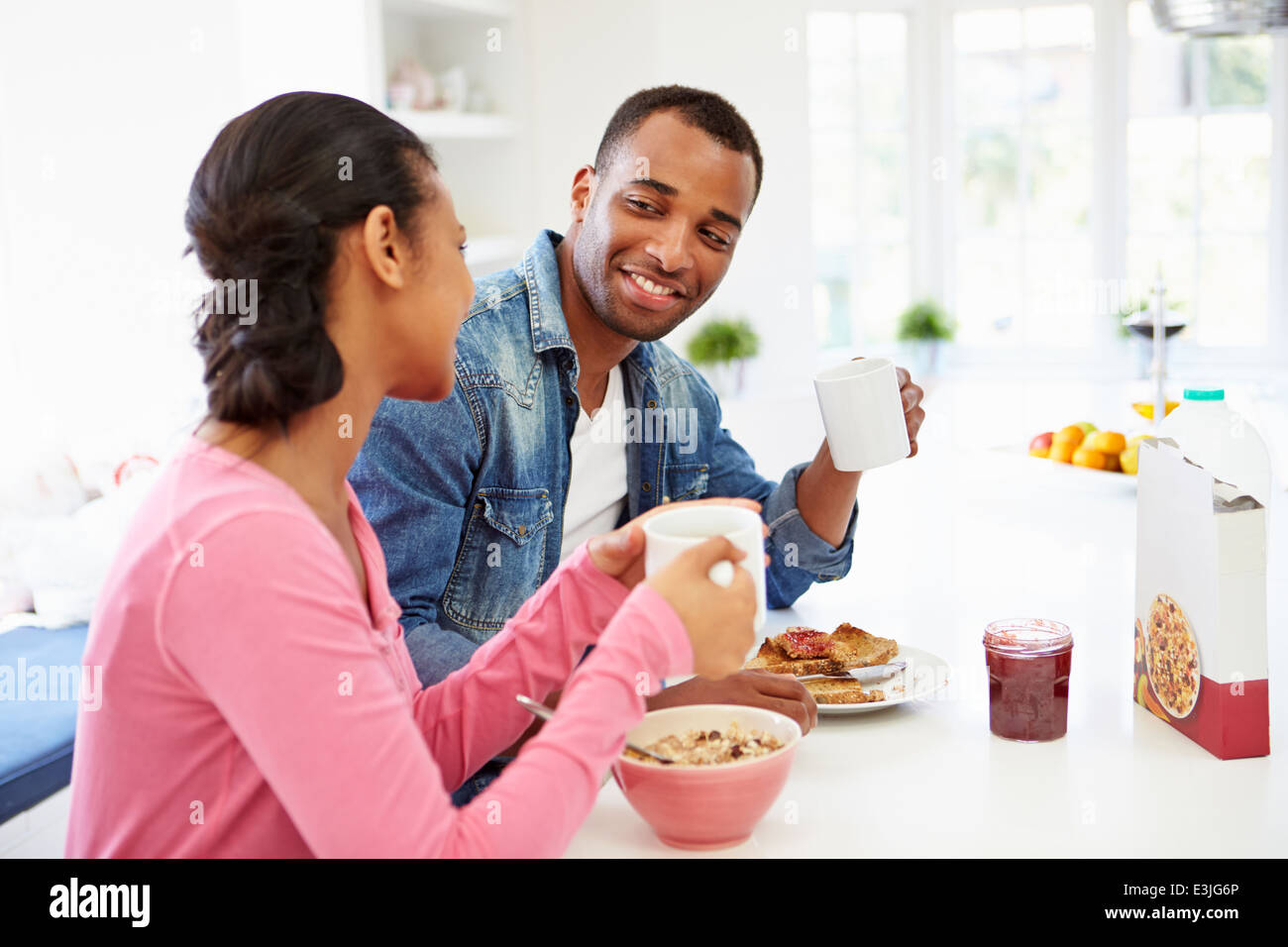 Couple Having Breakfast In Kitchen Together Stock Photo - Alamy