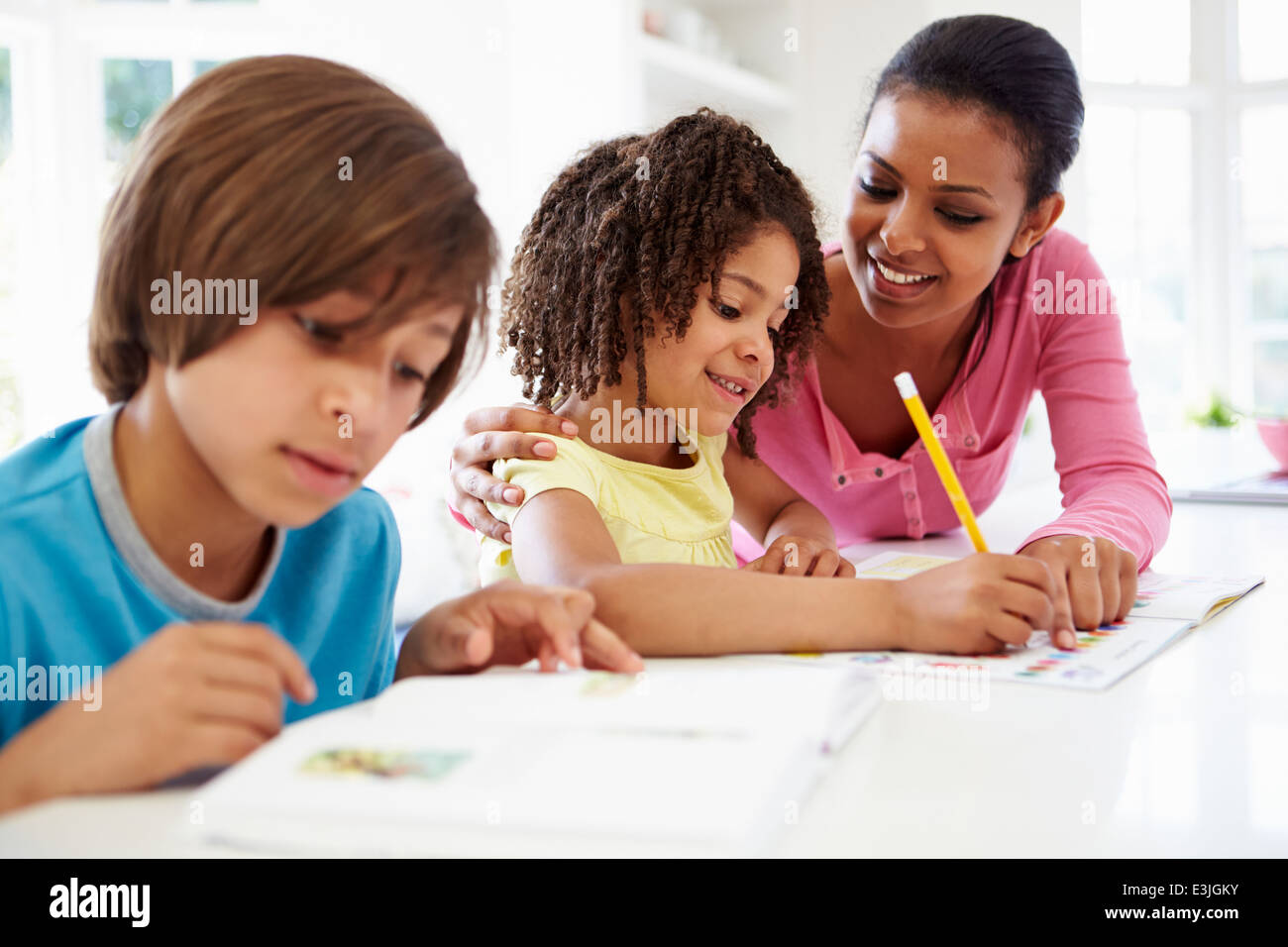 Mother Helping Children With Homework In Kitchen Stock Photo - Alamy