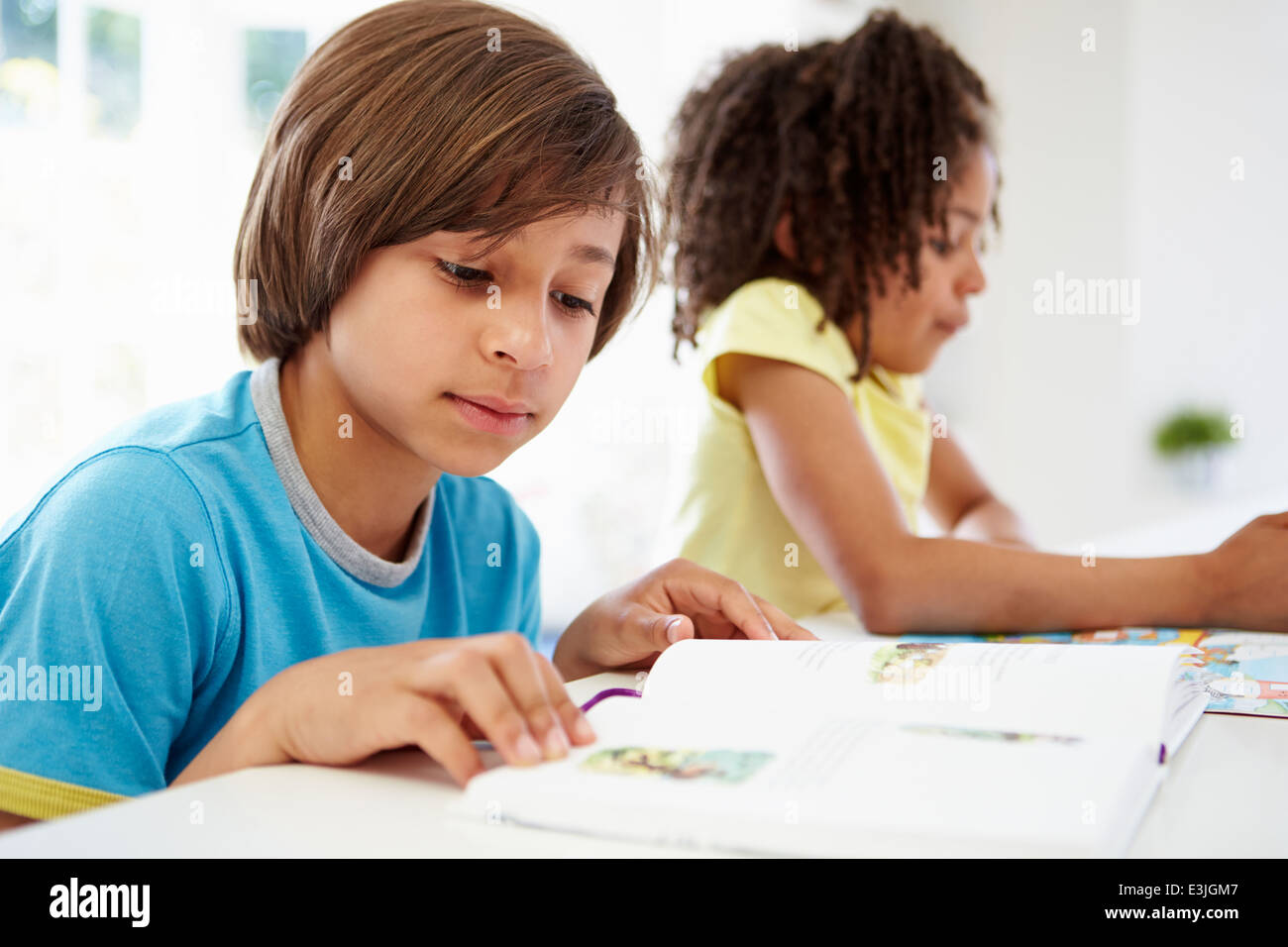 Children Doing Homework In Kitchen Together Stock Photo - Alamy