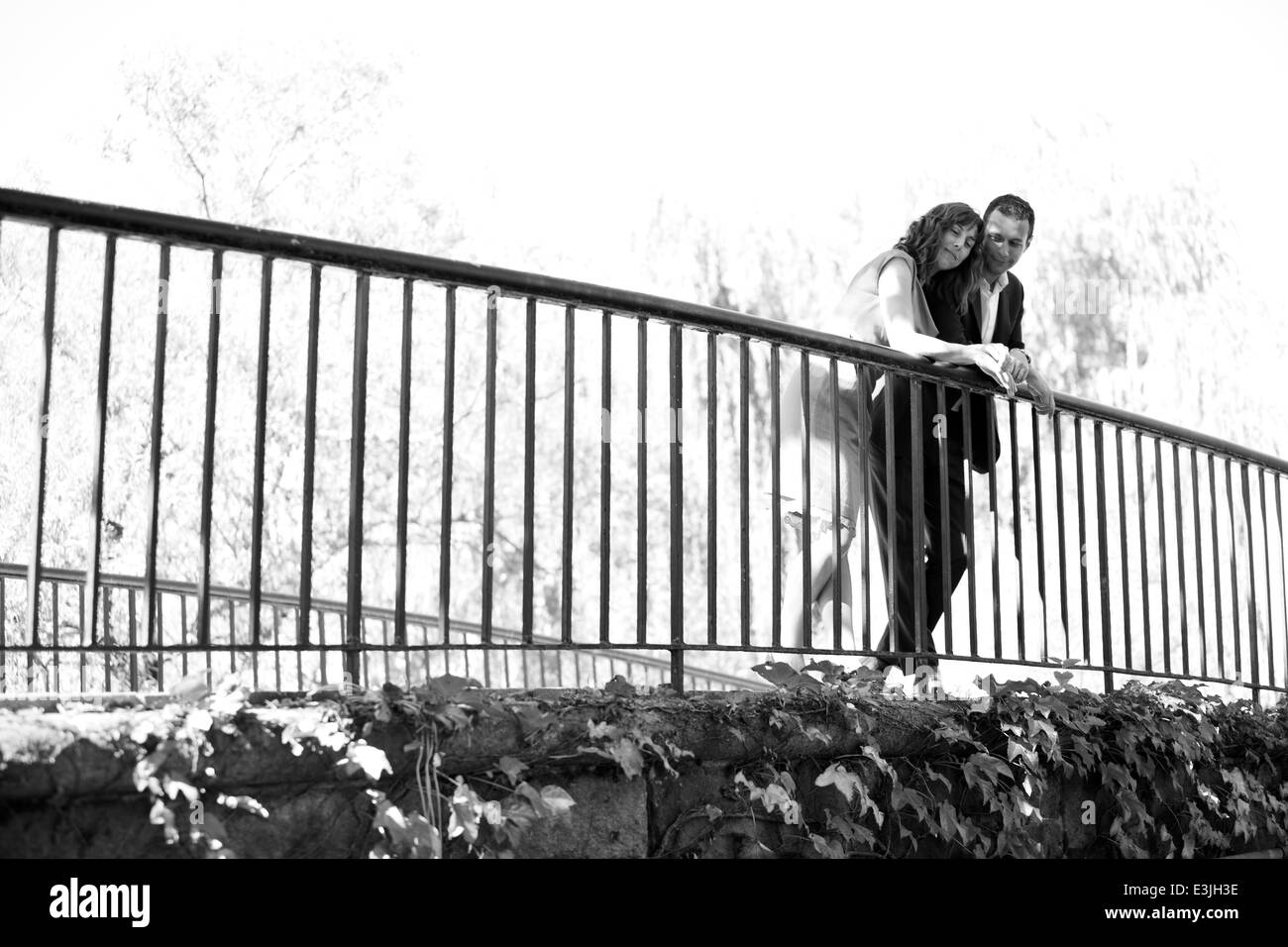 Couple standing side by side on bridge Black and White Stock Photos ...