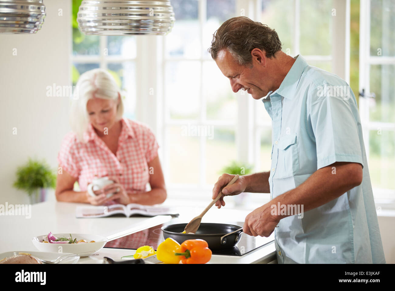 Middle Aged Couple Cooking Meal In Kitchen Together Stock Photo - Alamy