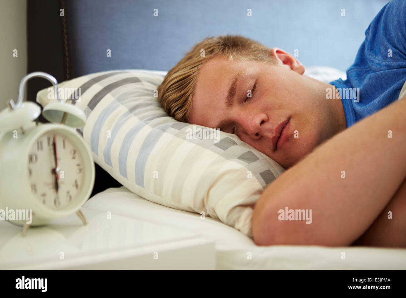Teenage Boy Sleeping Through Alarm Stock Photo - Alamy