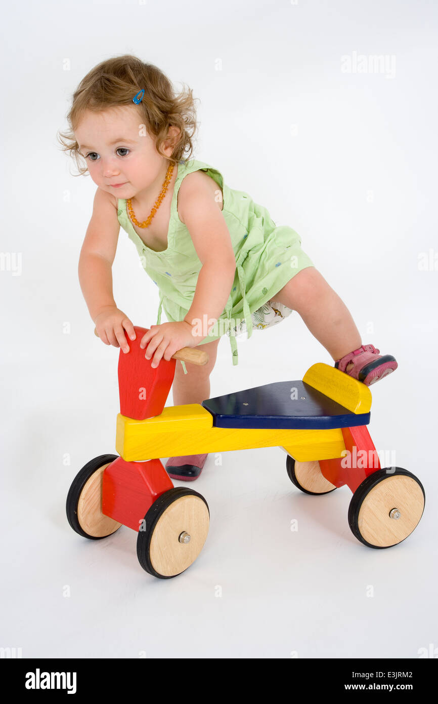 Toddler 18-24 months riding wooden bike Stock Photo - Alamy