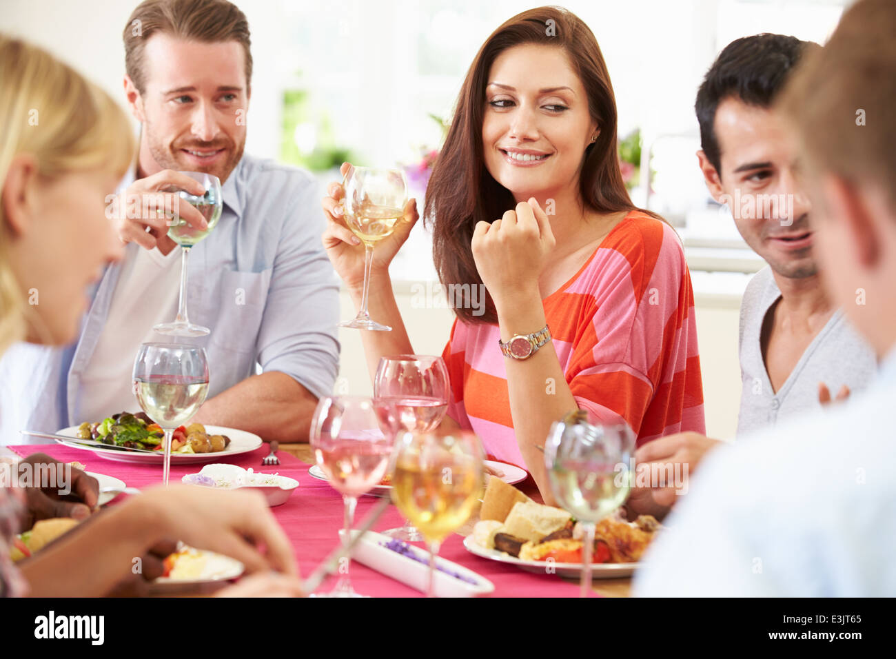 Group Of Friends Sitting Around Table Having Dinner Party Stock Photo ...