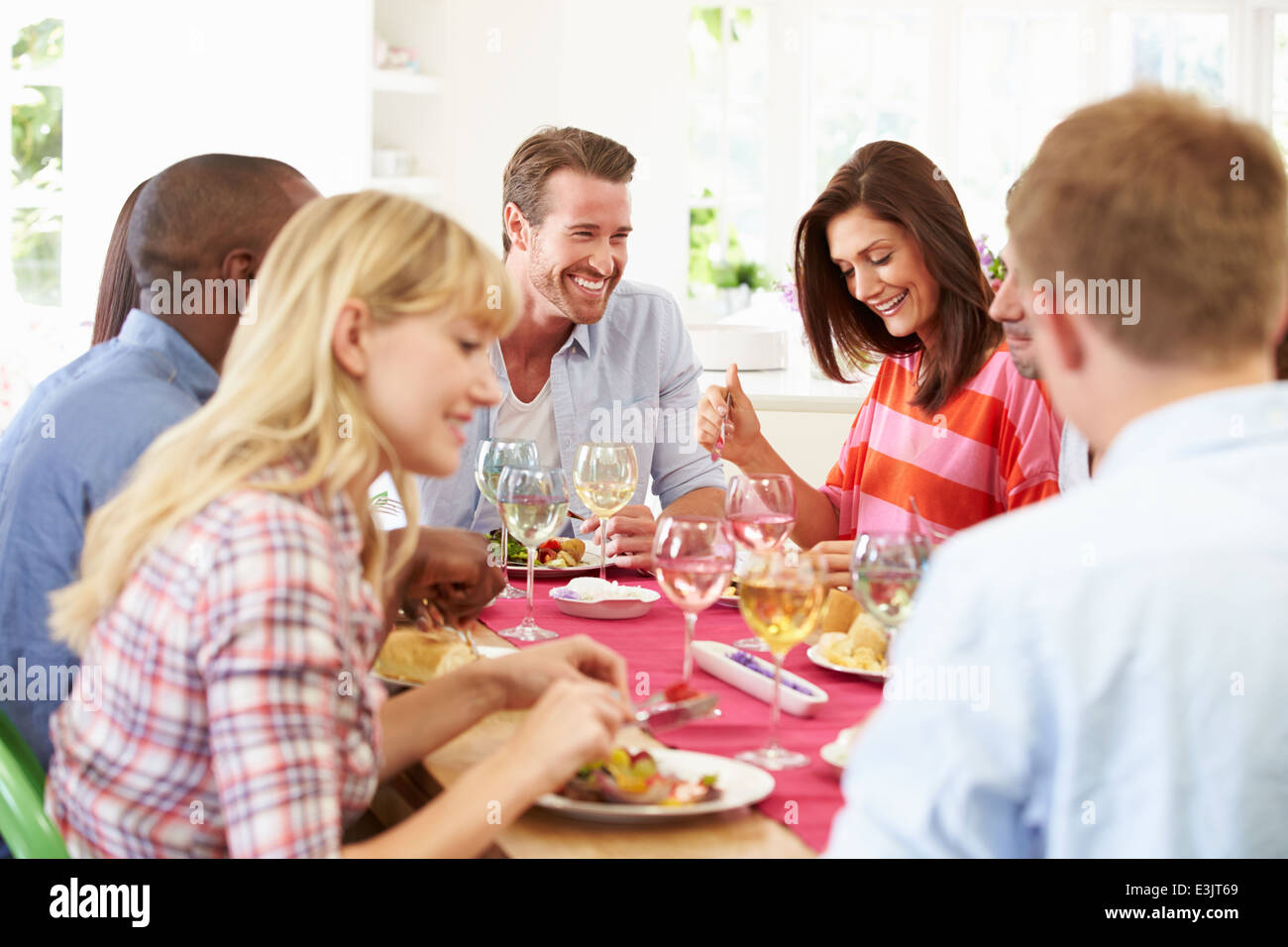 Group Of Friends Sitting Around Table Having Dinner Party Stock Photo ...