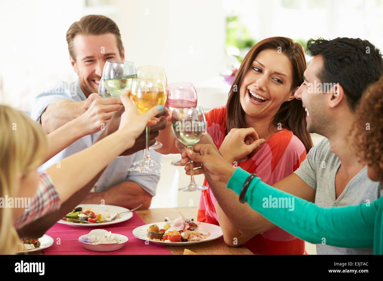 Group Of Friends Making Toast Around Table At Dinner Party Stock Photo ...