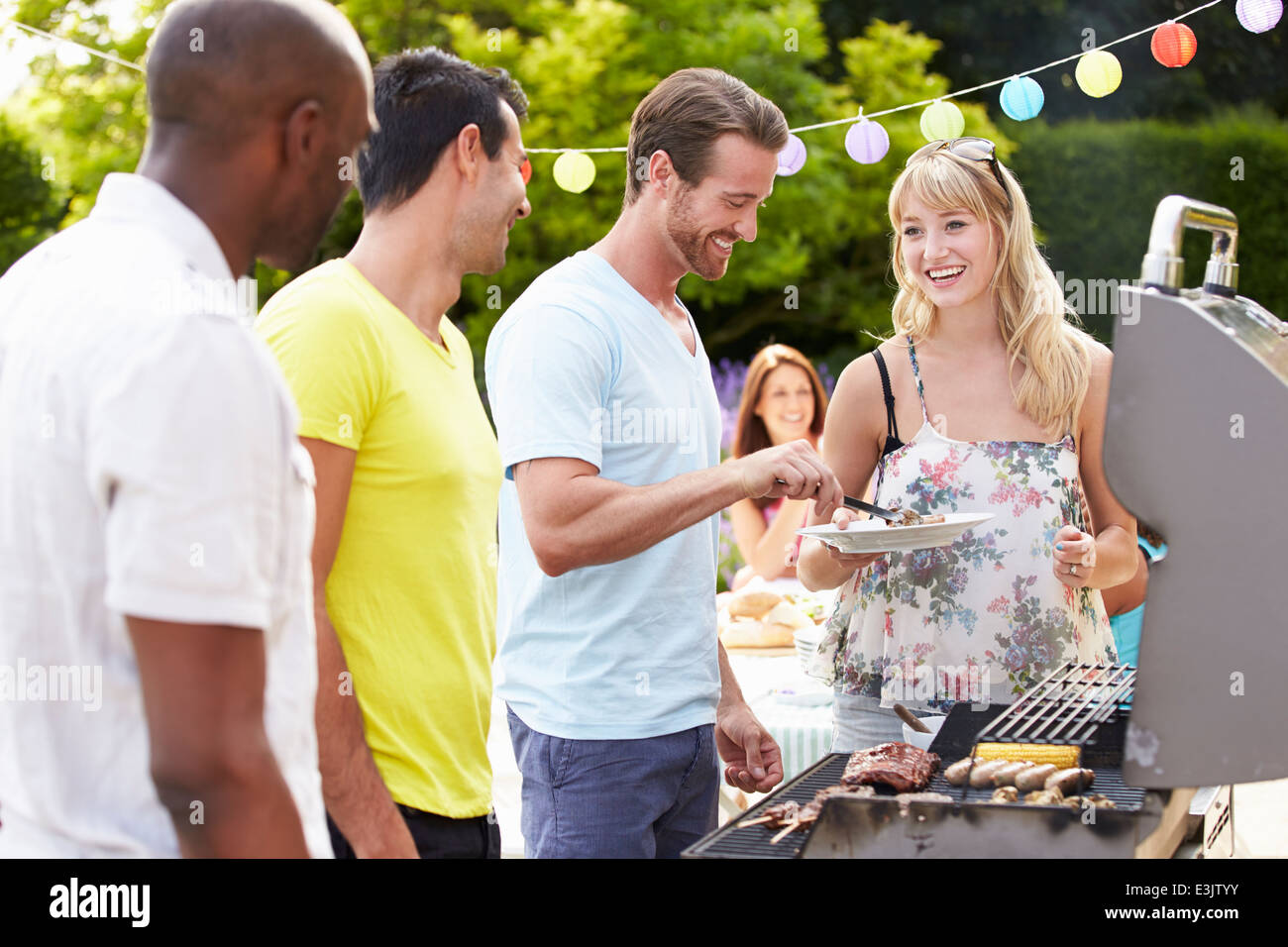 Group Of Friends Having Outdoor Barbeque At Home Stock Photo - Alamy