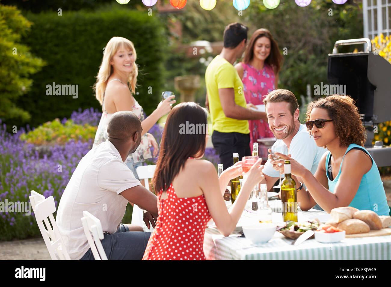 Group Of Friends Having Outdoor Barbeque At Home Stock Photo - Alamy