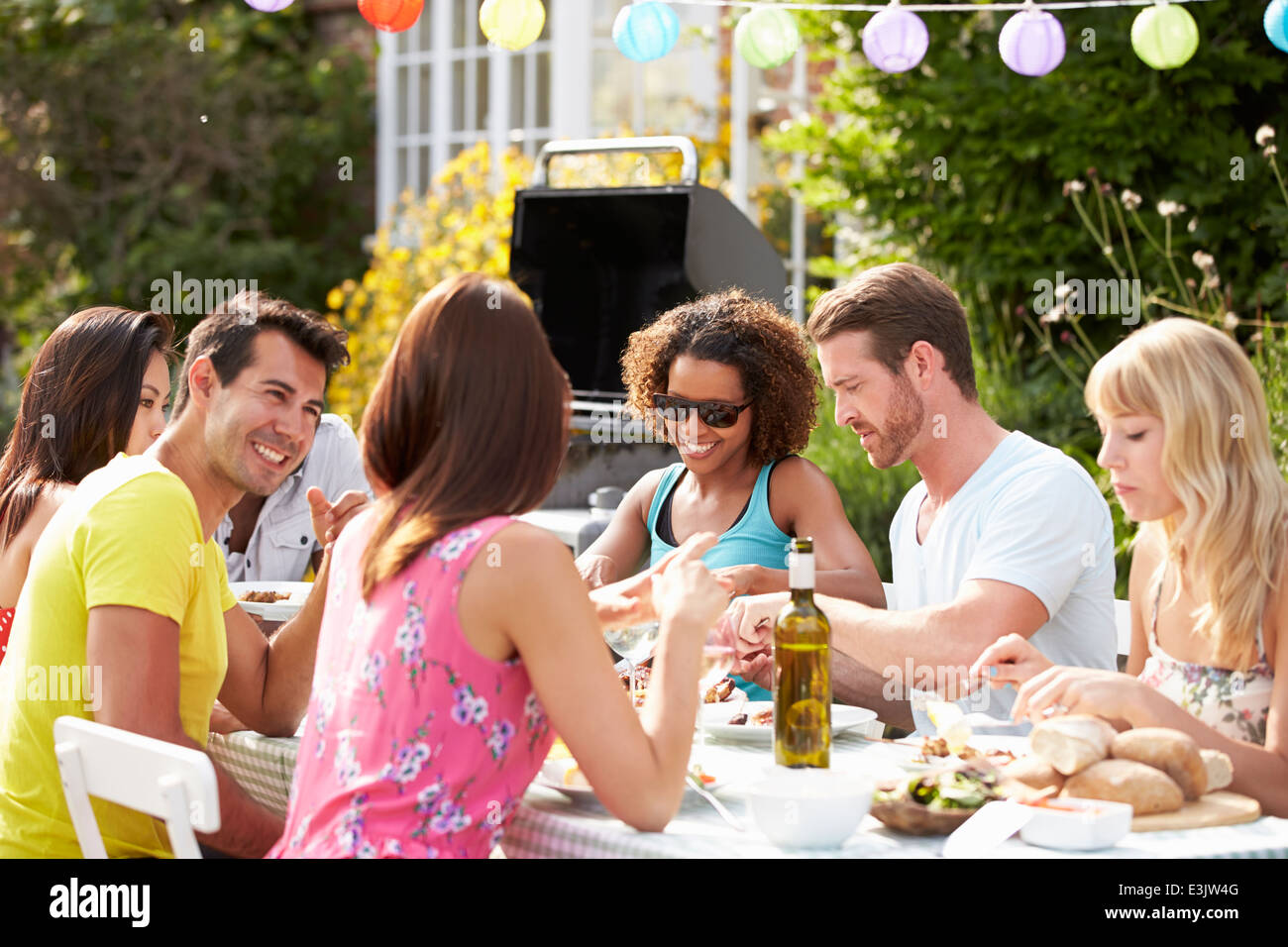 Group Of Friends Having Outdoor Barbeque At Home Stock Photo - Alamy