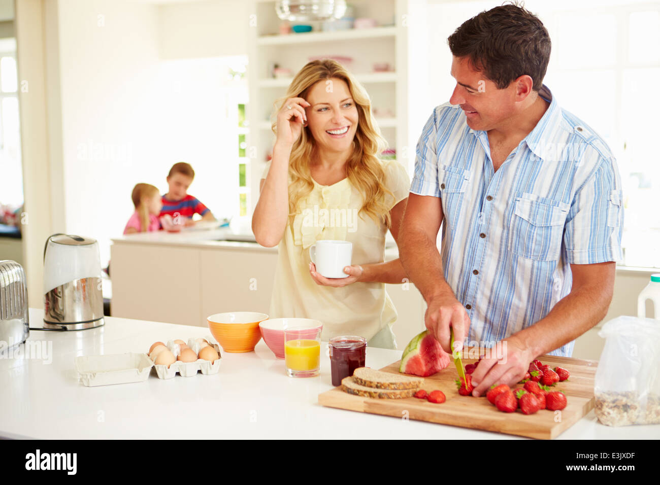 Parents Preparing Family Breakfast In Kitchen Stock Photo - Alamy