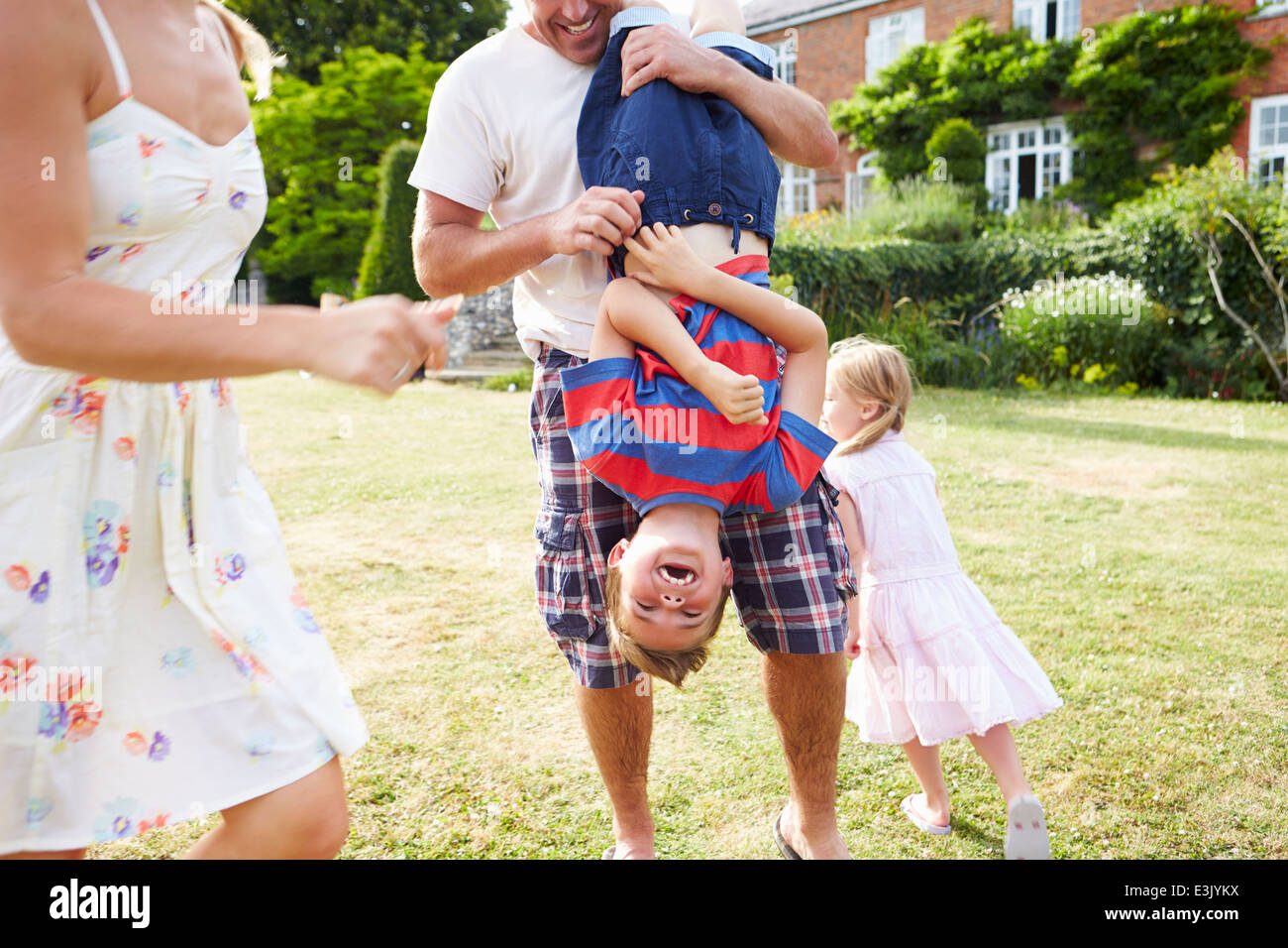 Family Having Fun Playing In Garden Stock Photo - Alamy