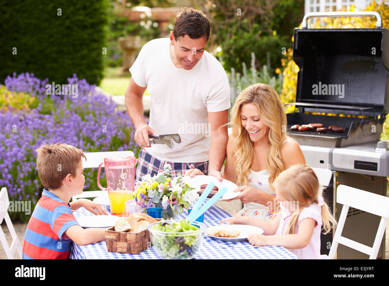 Family Enjoying Outdoor Barbeque In Garden Stock Photo - Alamy