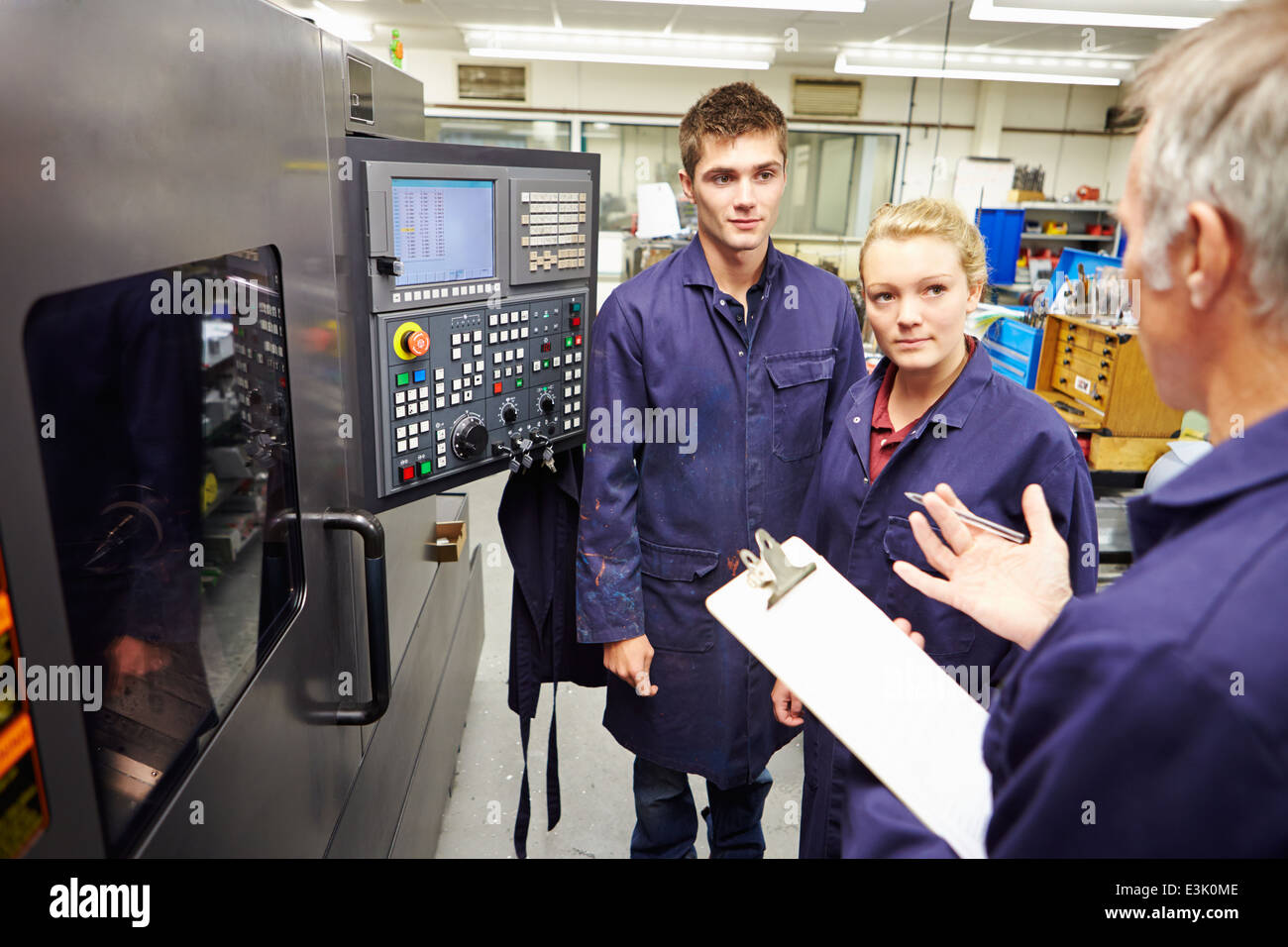Engineer Teaching Apprentices To Use Computerized Lathe Stock Photo - Alamy