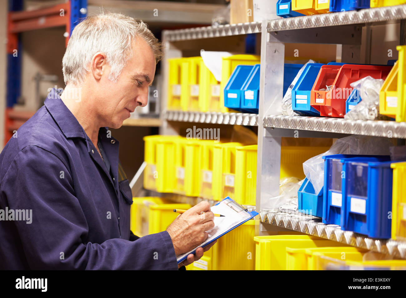 Worker Checking Stock Levels In Store Room Stock Photo - Alamy