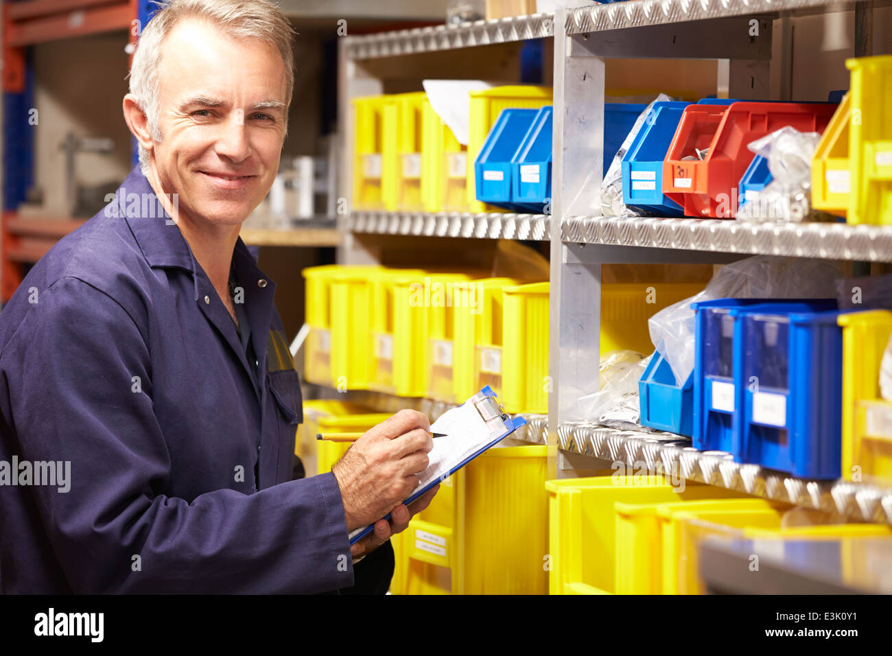 Worker Checking Stock Levels In Store Room Stock Photo - Alamy