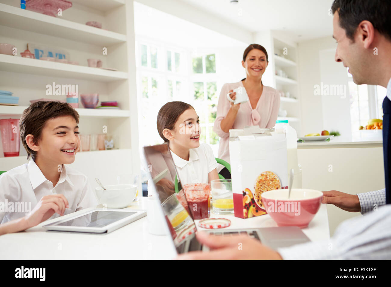 Family Using Digital Devices At Breakfast Table Stock Photo - Alamy