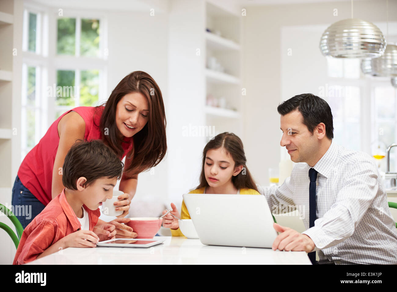 Family Using Digital Devices At Breakfast Table Stock Photo - Alamy