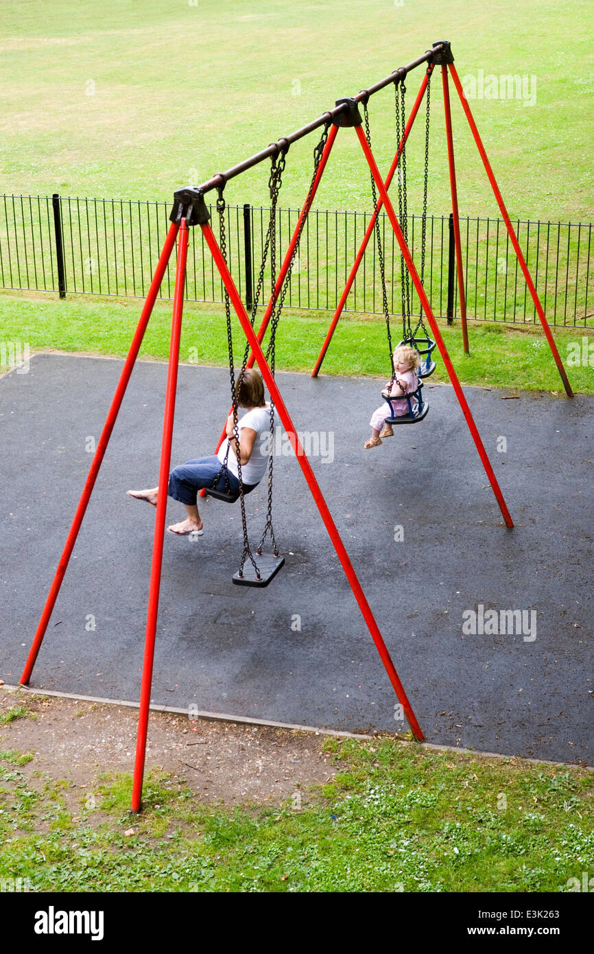 Mother and daughter on swings in park Stock Photo - Alamy