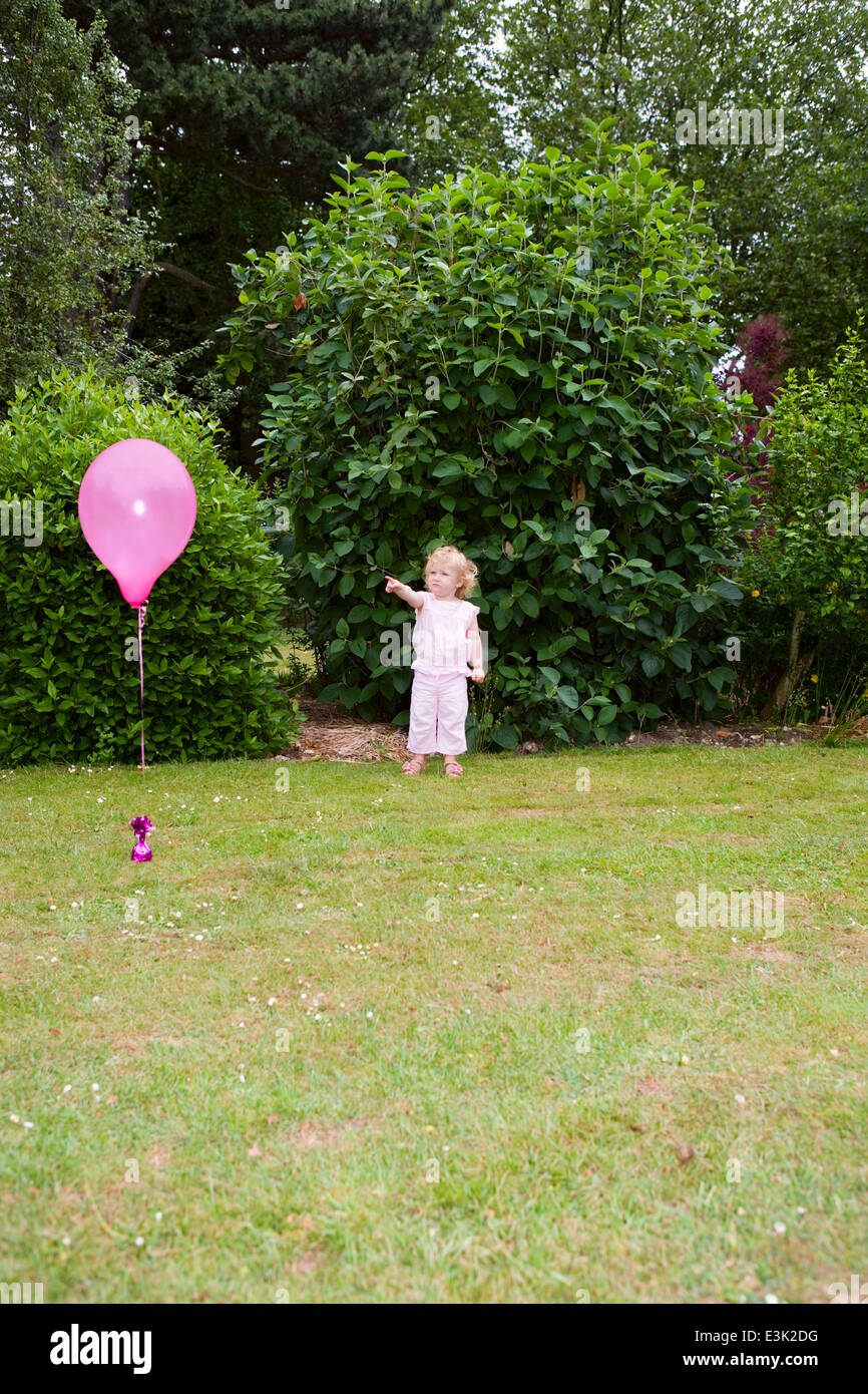 Child pointing at pink balloon Stock Photo - Alamy