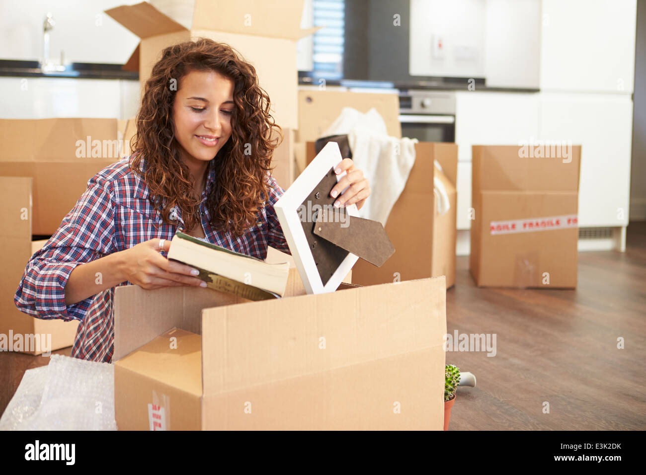 Woman Moving Into New Home And Unpacking Boxes Stock Photo - Alamy