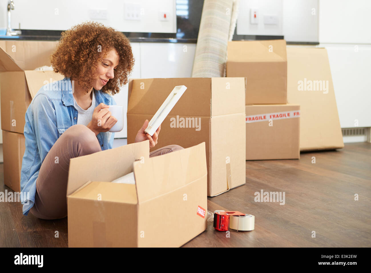 Woman Moving Into New Home And Unpacking Boxes Stock Photo - Alamy