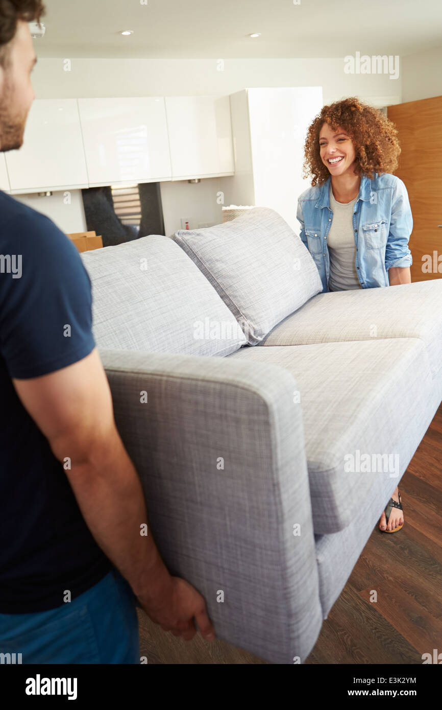 Couple Carrying Sofa As They Move Into New Home Stock Photo - Alamy