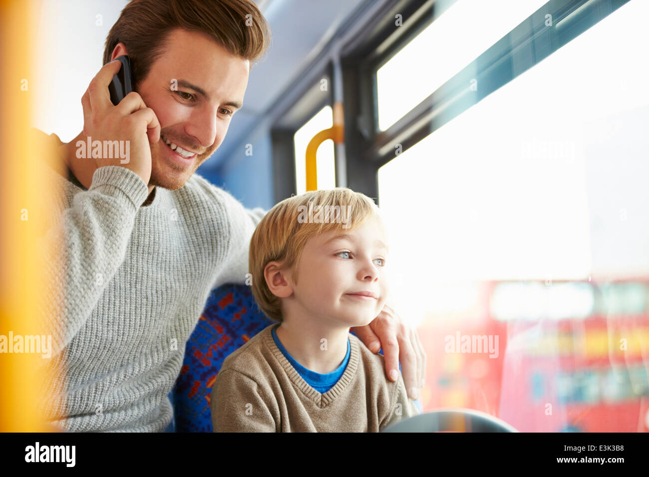 Father Using Mobile Phone On Bus Journey With Son Stock Photo - Alamy