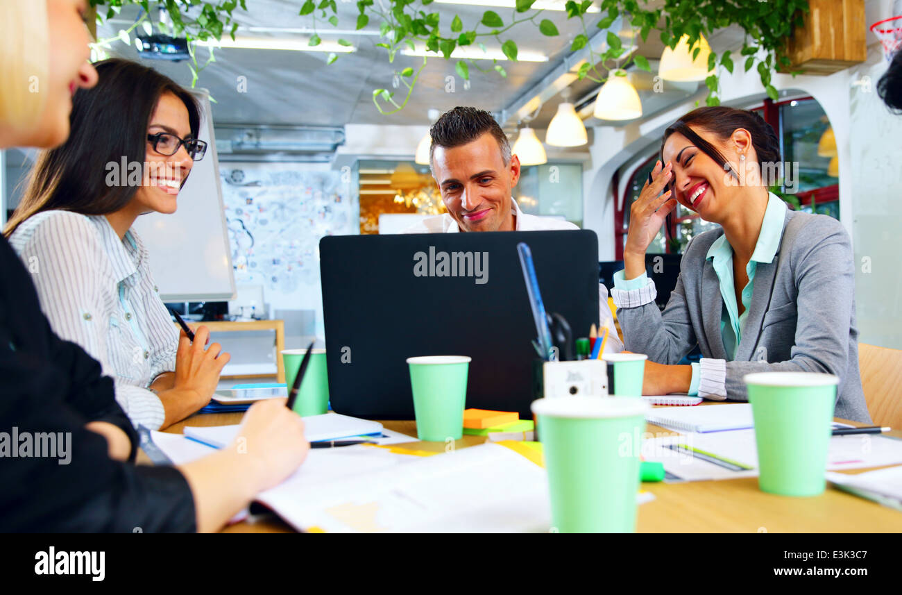 Happy businesspeople working together around the table in office Stock ...