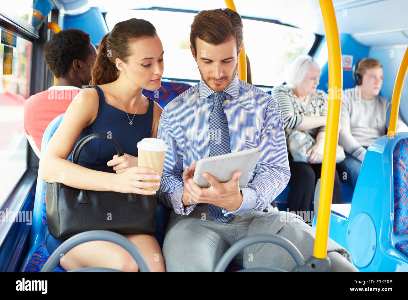 Businessman And Woman Using Digital Tablet On Bus Stock Photo - Alamy