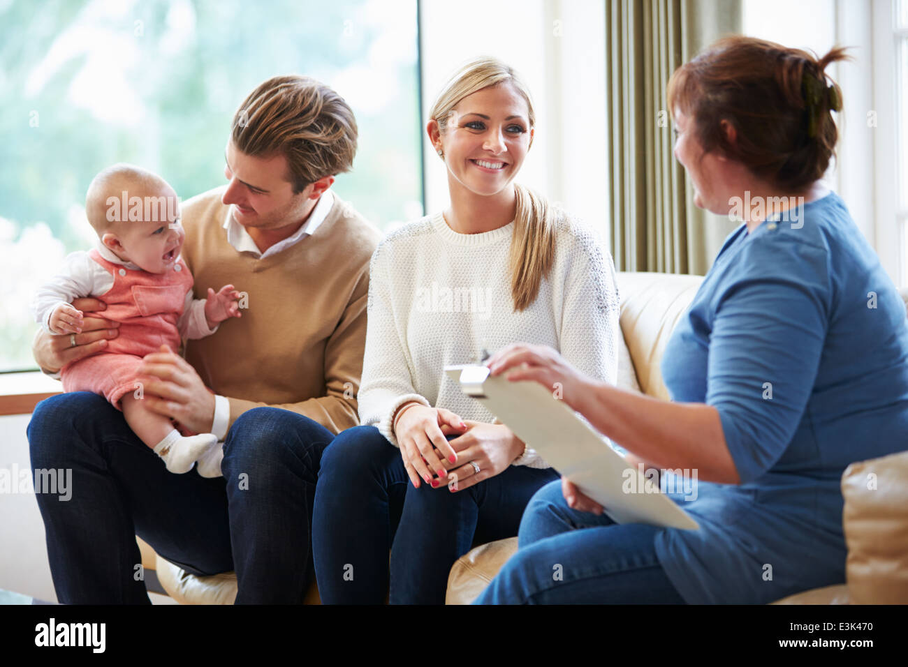 Health Visitor Talking To Family With Young Baby Stock Photo - Alamy