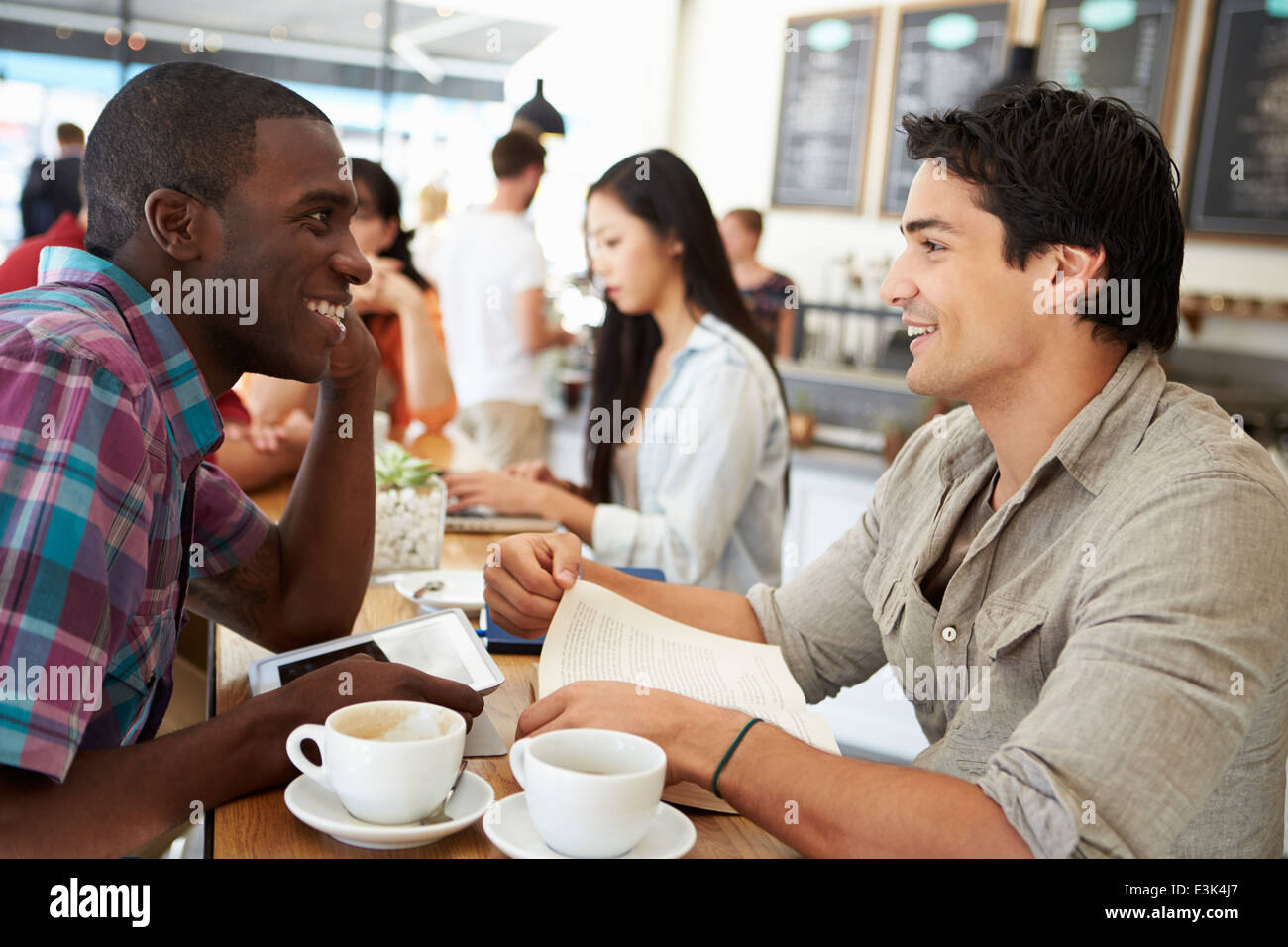 Two Male Friends Meeting In Busy Coffee Shop Stock Photo - Alamy