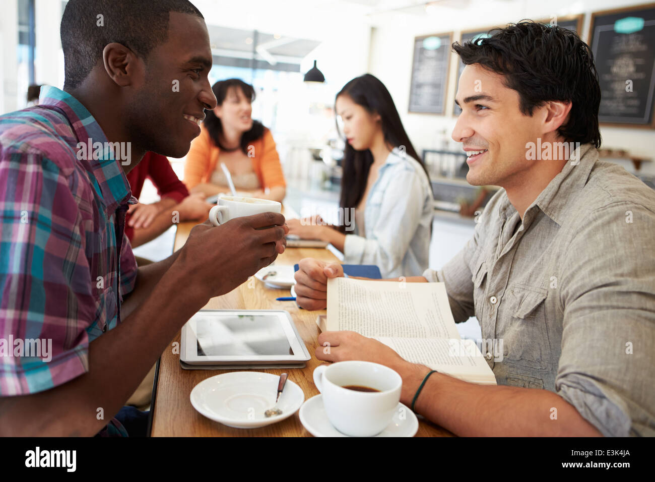 Two Male Friends Meeting In Busy Coffee Shop Stock Photo - Alamy
