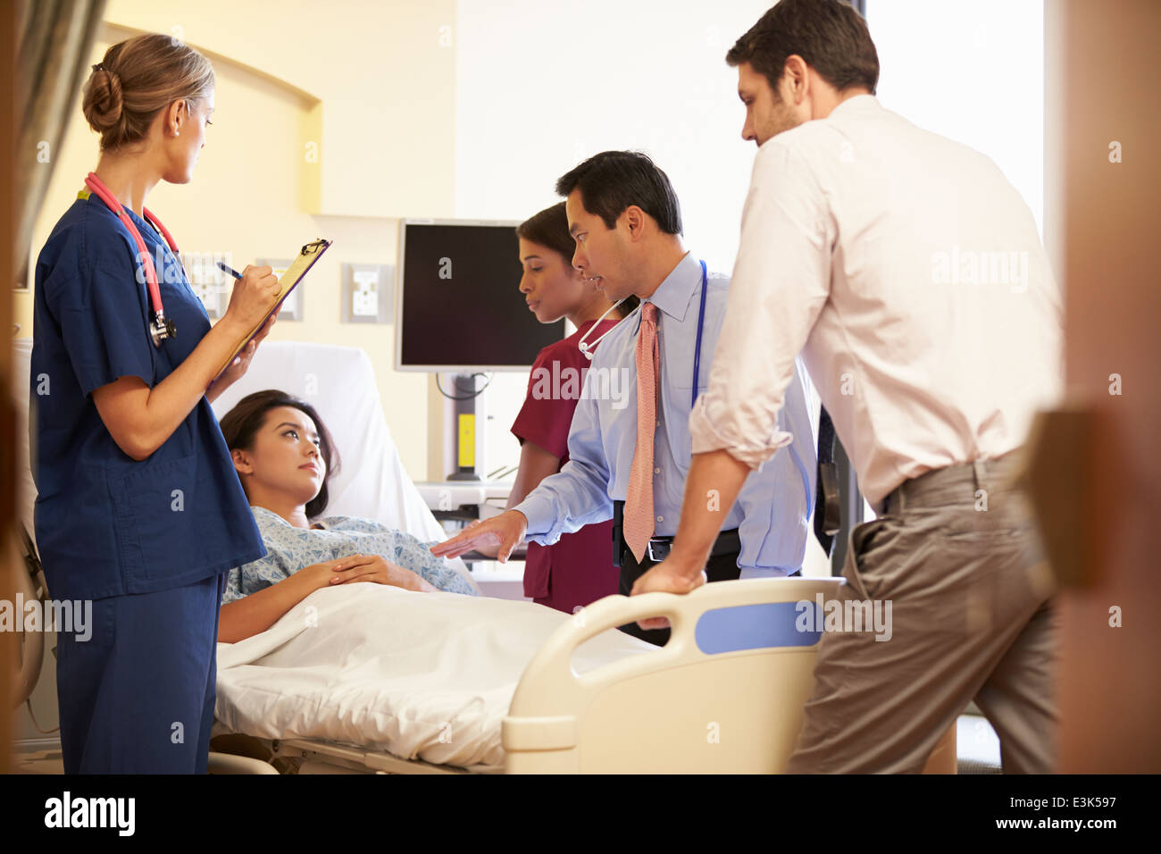 Medical Team Meeting Around Female Patient In Hospital Room Stock Photo ...