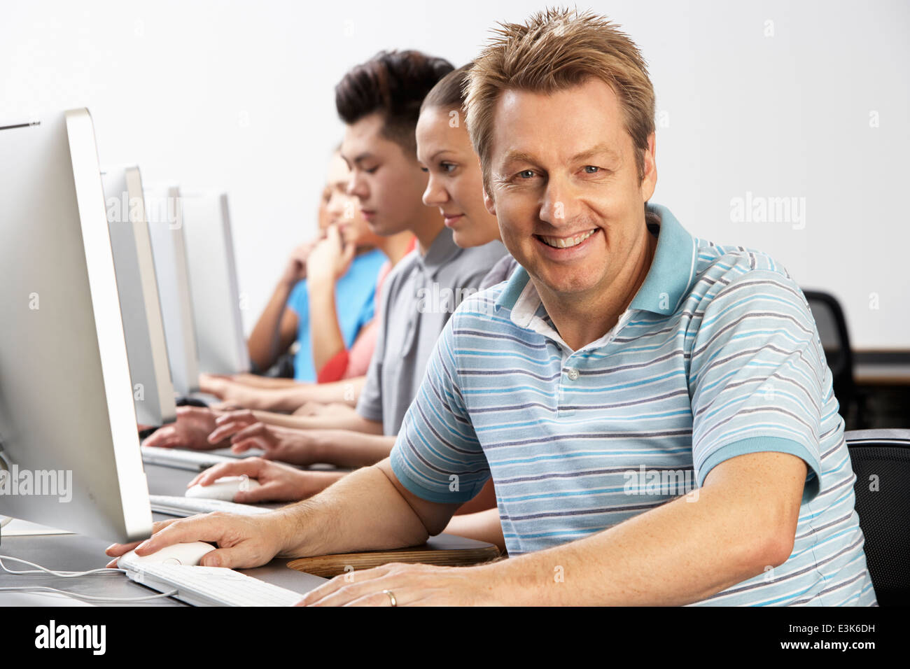 Portrait Of Tutor With Students In Computer Class Stock Photo - Alamy