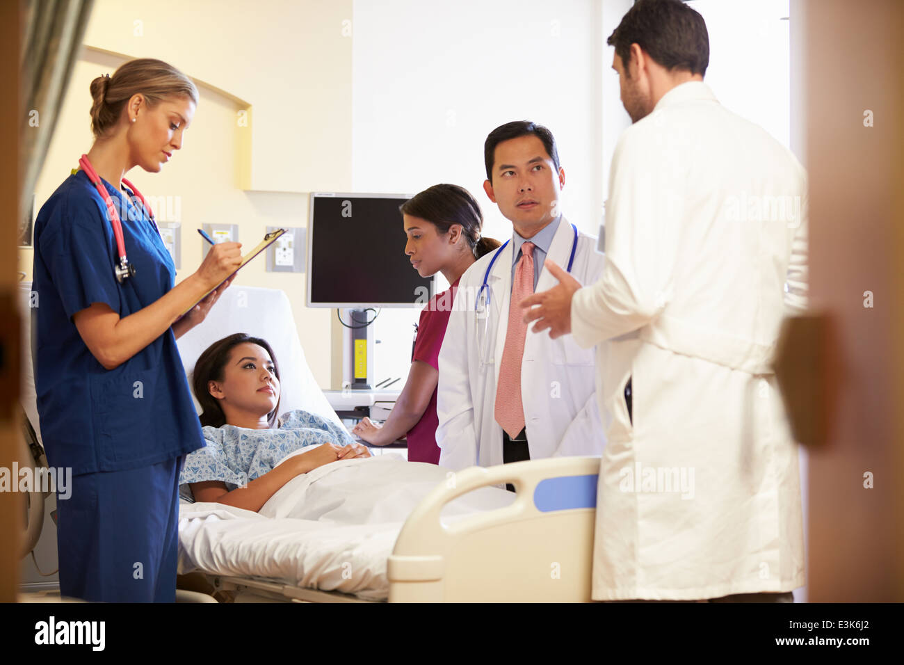 Medical Team Meeting Around Female Patient In Hospital Room Stock Photo ...