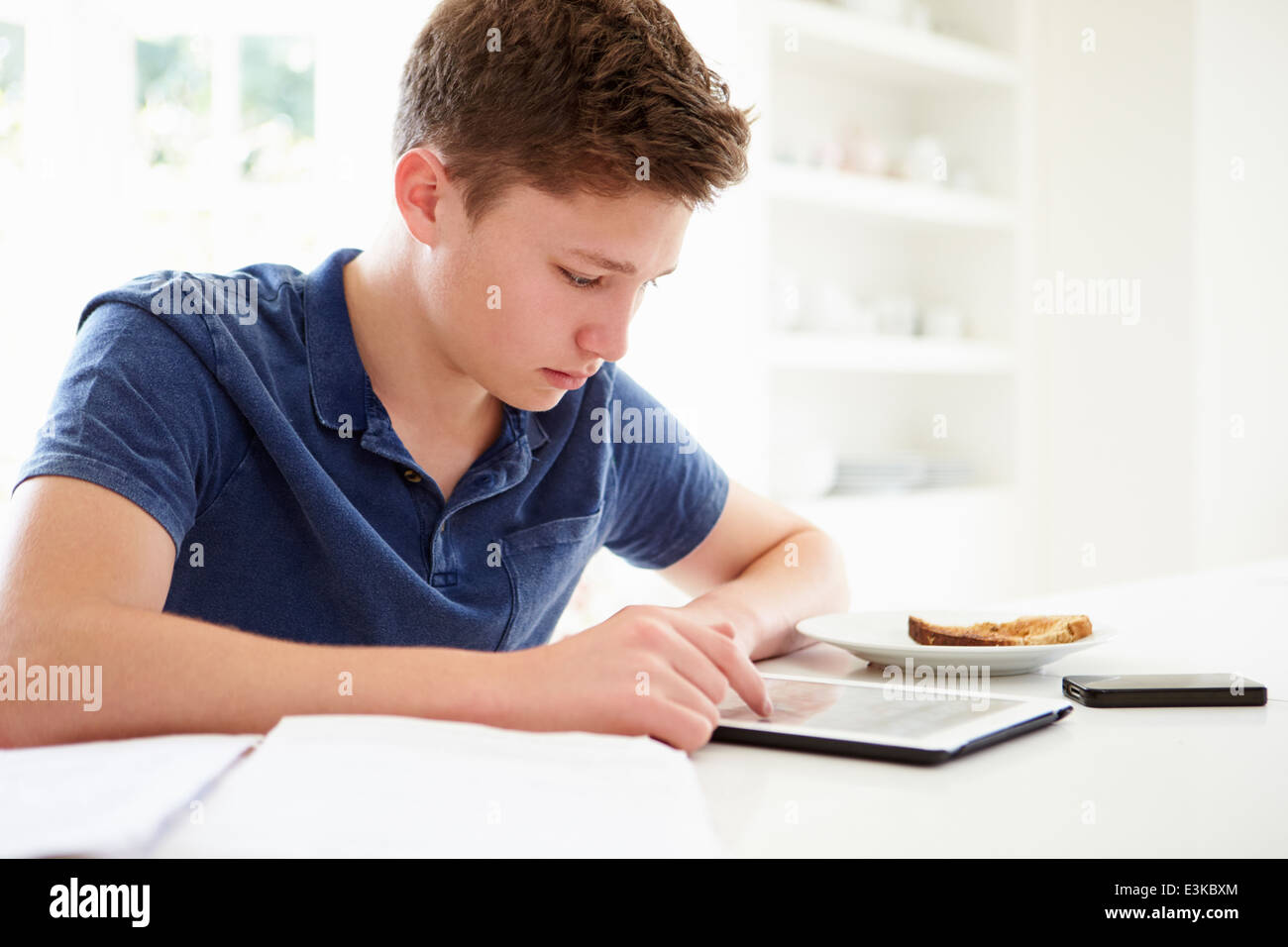 Teenage Boy Studying Using Digital Tablet At Home Stock Photo - Alamy
