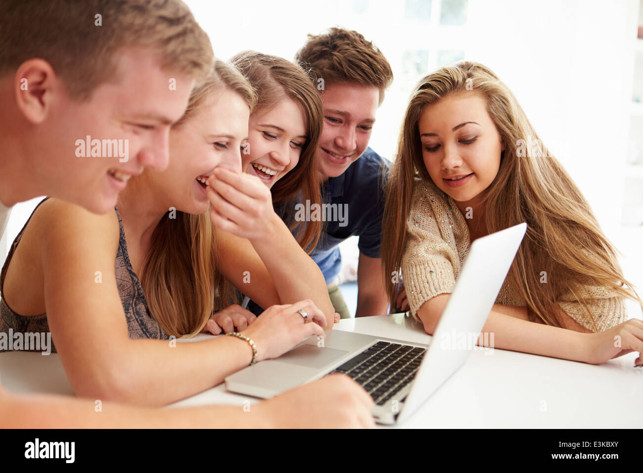 Group Of Teenagers Gathered Around Laptop Together Stock Photo - Alamy