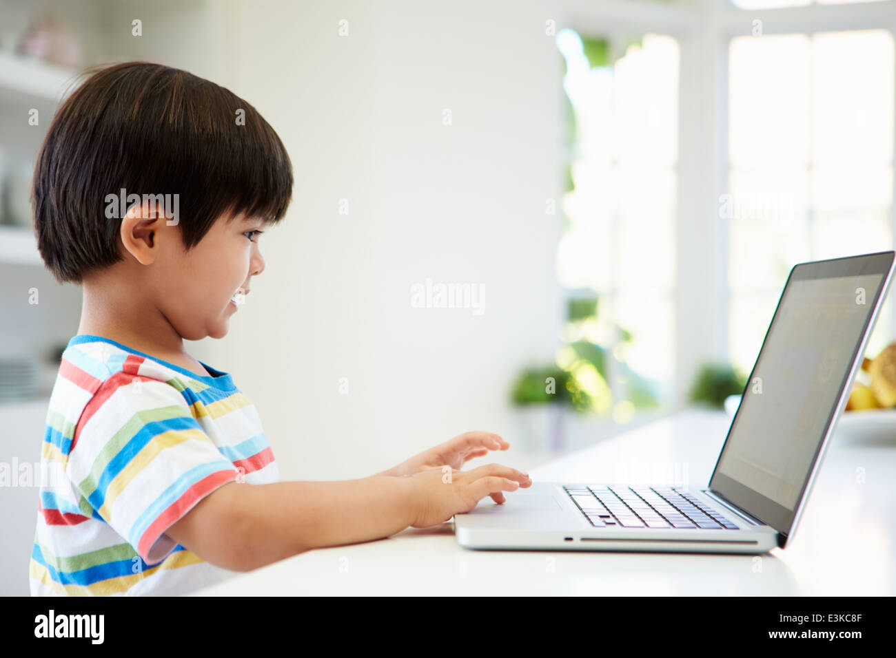 Asian Child Using Laptop At Home Stock Photo - Alamy