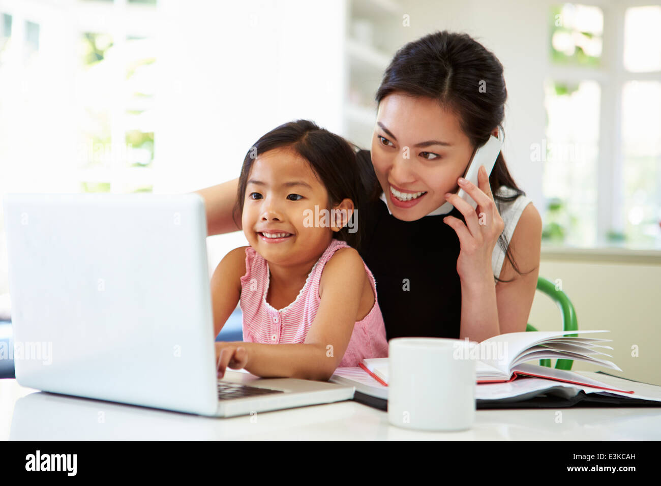Busy Mother Working From Home With Daughter Stock Photo - Alamy