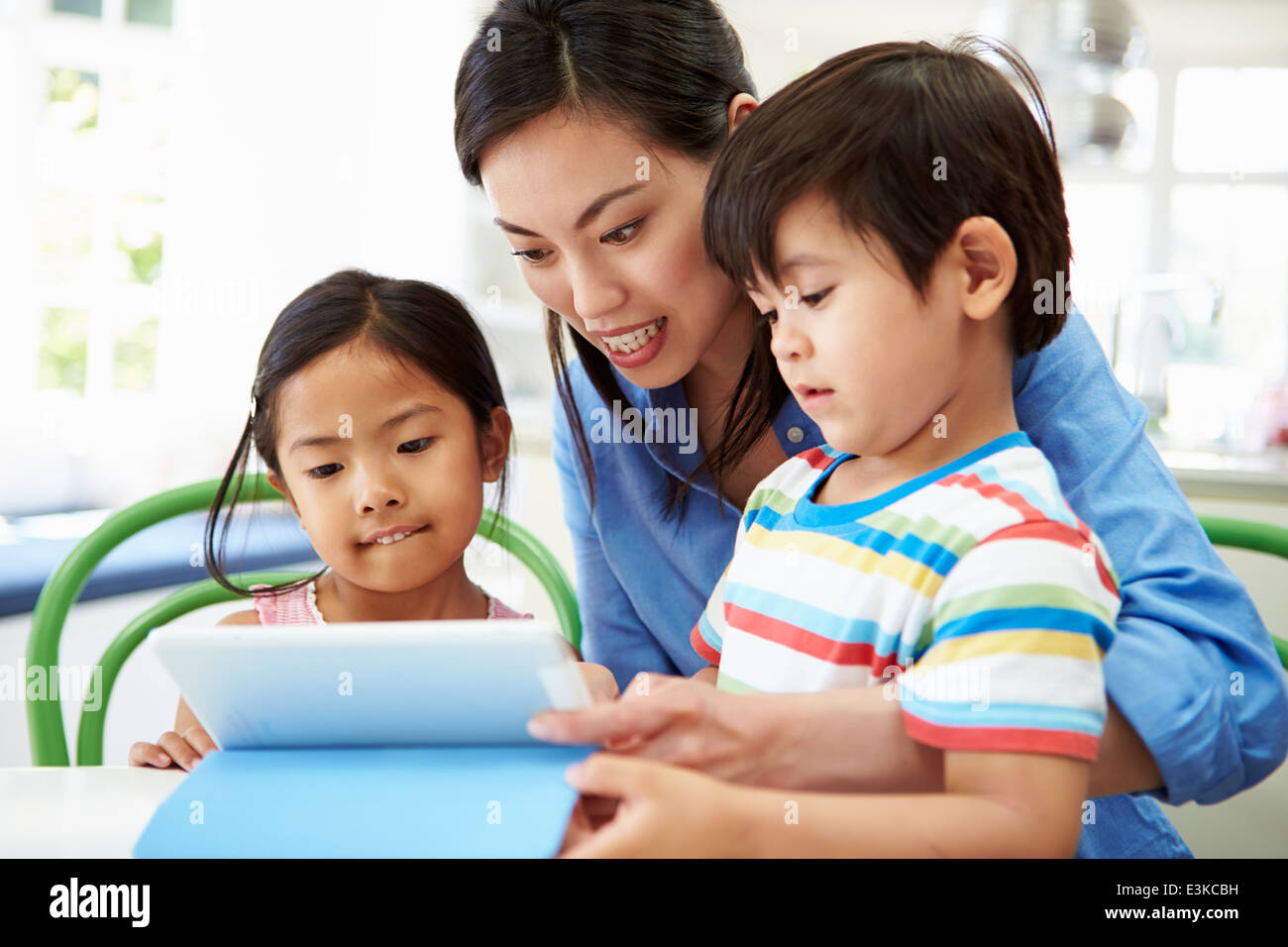 Mother Helping Children With Homework Using Digital Tablet Stock Photo ...