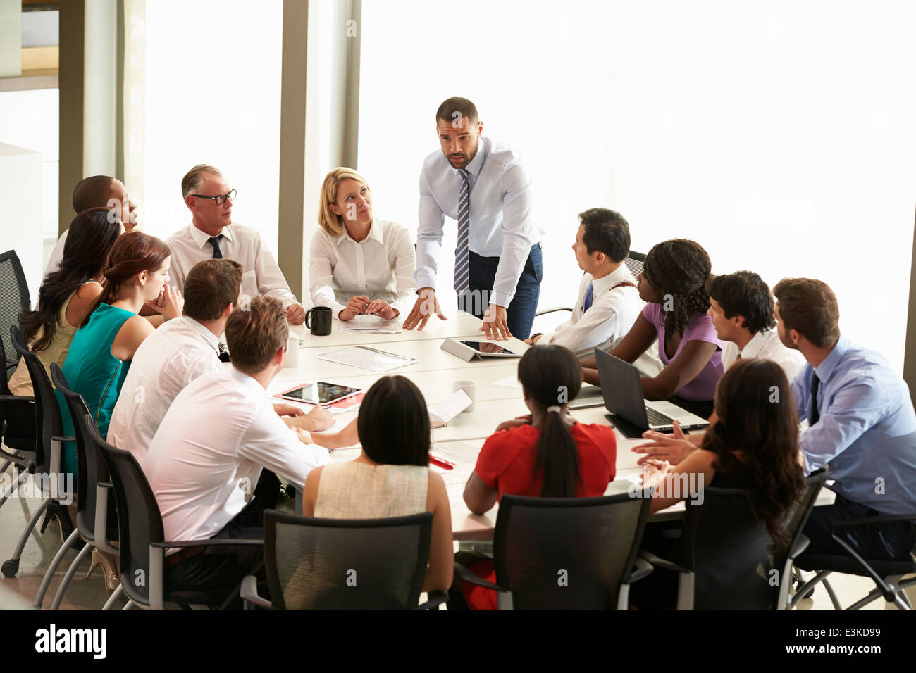Businessman Addressing Meeting Around Boardroom Table Stock Photo - Alamy