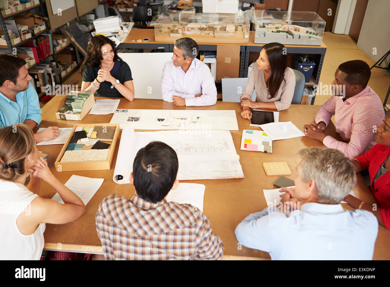 Group Of Architects Sitting Around Table Having Meeting Stock Photo - Alamy