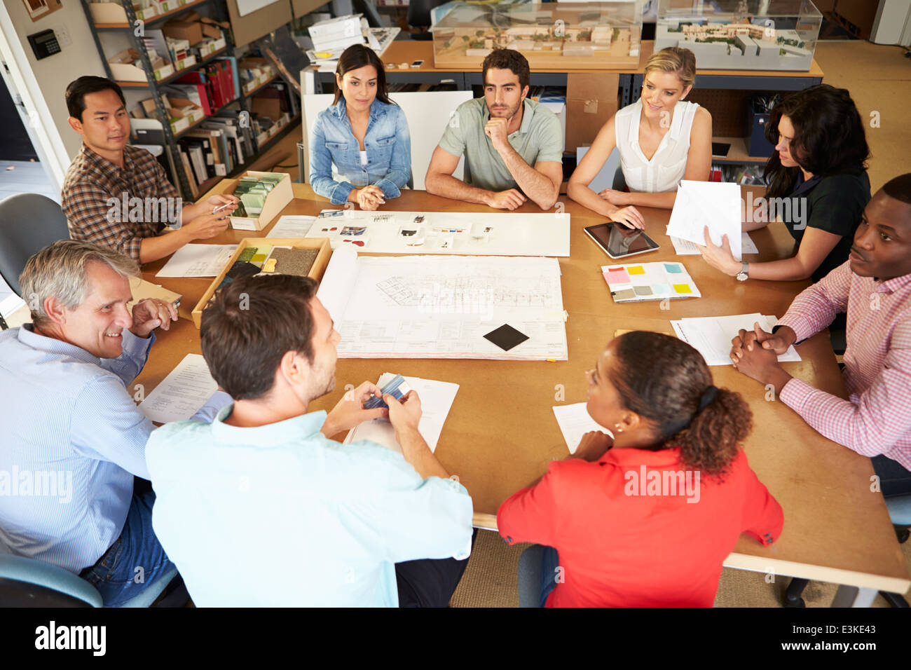 Group Of Architects Sitting Around Table Having Meeting Stock Photo - Alamy