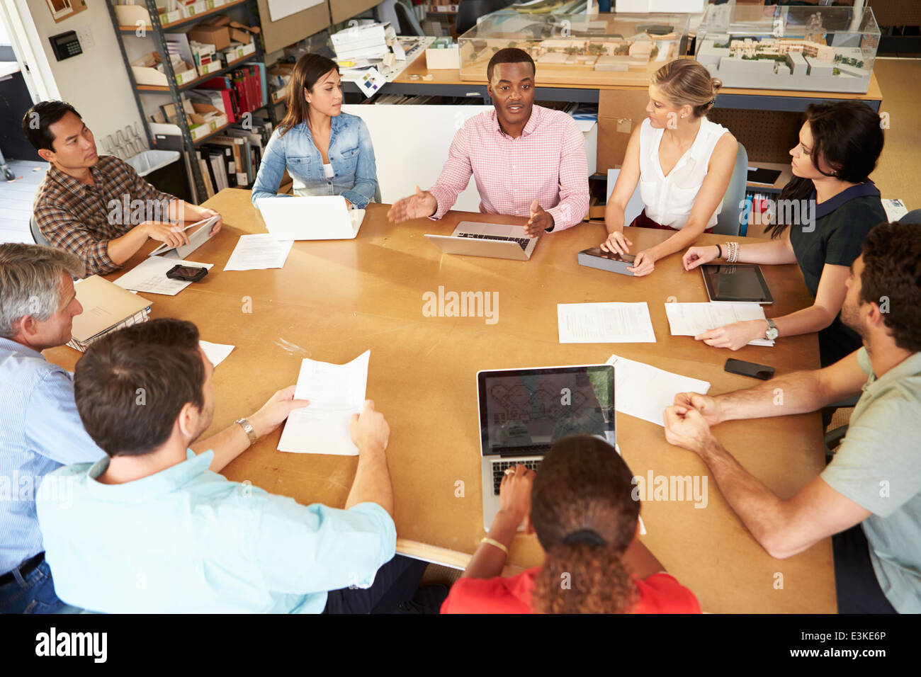 Group Of Architects Sitting Around Table Having Meeting Stock Photo - Alamy