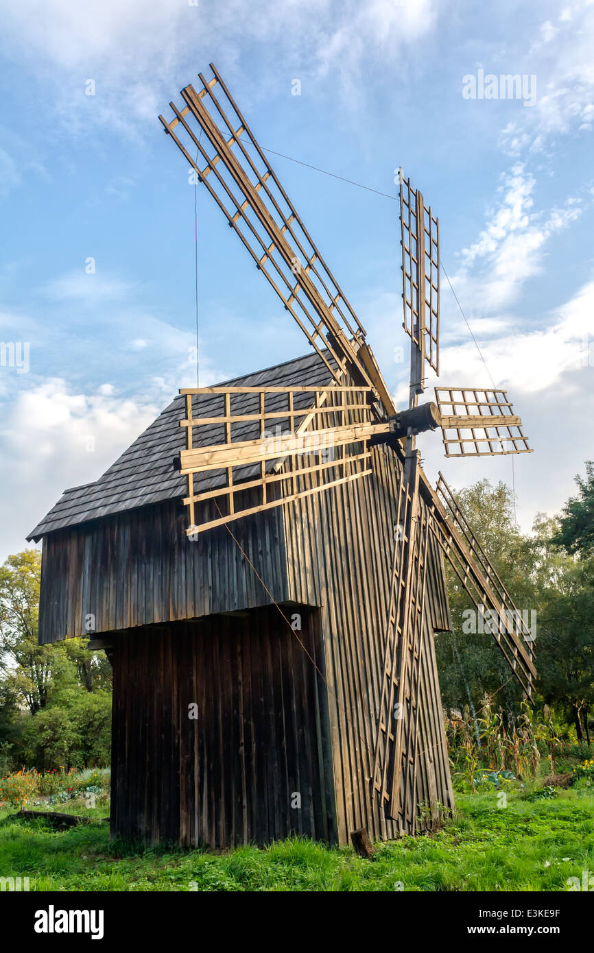 Old wooden traditional ukrainian windmill on green grass over blue sky ...