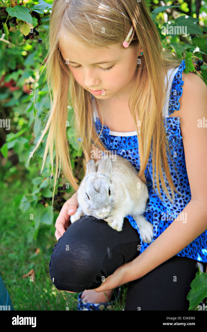 Teenage girl playing with a rabbit in the backyard Stock Photo - Alamy