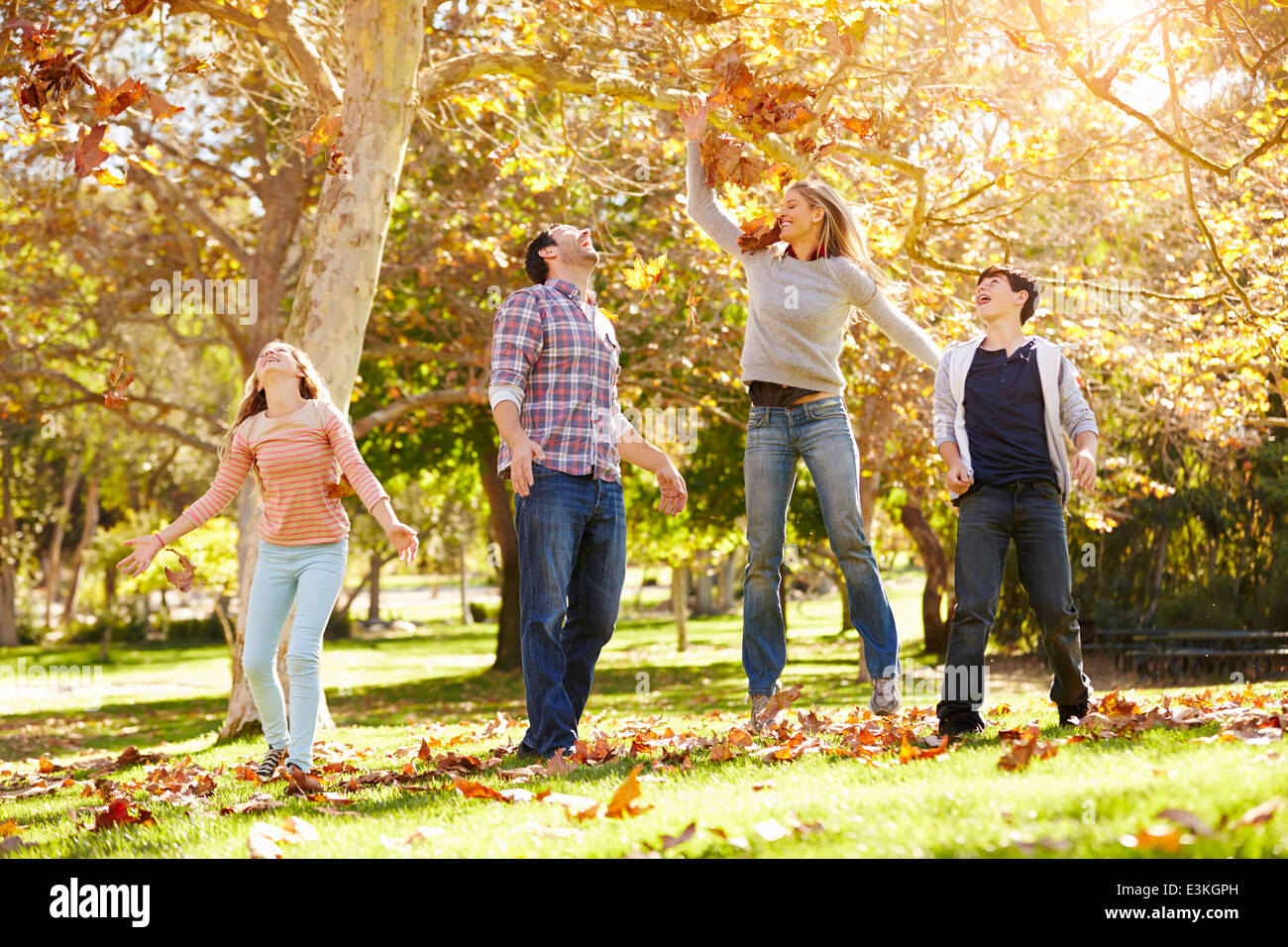 Family Throwing Autumn Leaves In The Air Stock Photo - Alamy