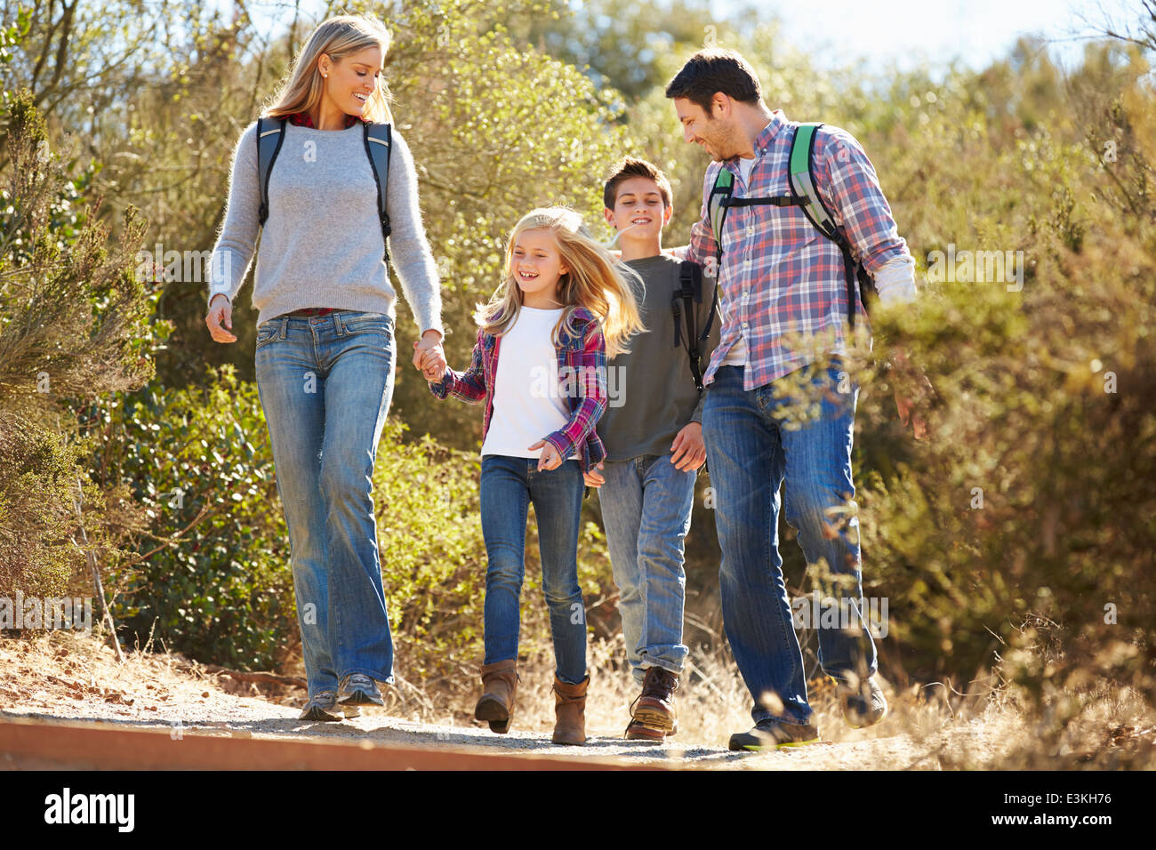 Family Hiking In Countryside Wearing Backpacks Stock Photo - Alamy
